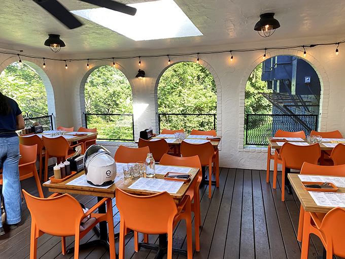 The covered patio offers a perfect perch for people-watching while orange chairs add pops of color to barbecue afternoons.