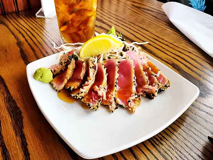 Sesame-crusted ahi tuna, seared rare and sliced to showcase its ruby center &ndash; evidence that Schu's seafood mastery extends beyond local favorites.
