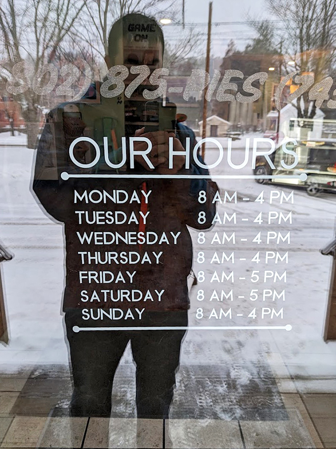 Hours posted on the door with a reflection of Chester's main street. Even in winter, this place warms souls from 8am to 4pm (5pm weekends!).