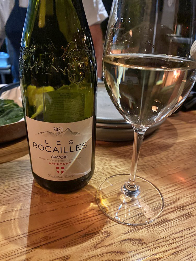 A glass of Les Rocailles Savoie – because sometimes the perfect wine pairing is what transforms a meal into a memory.