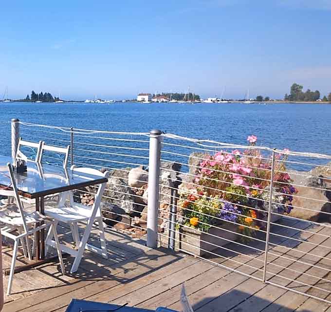Deck seating with flowers and lake views, where the hardest decision is whether to look at your food or the water.