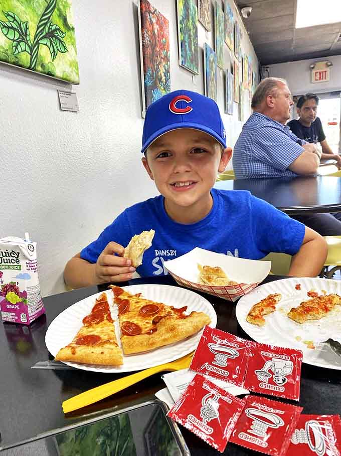 The joy of pizza knows no age limit, as this young Cubs fan demonstrates with his pepperoni slice and what appears to be garlic knots.