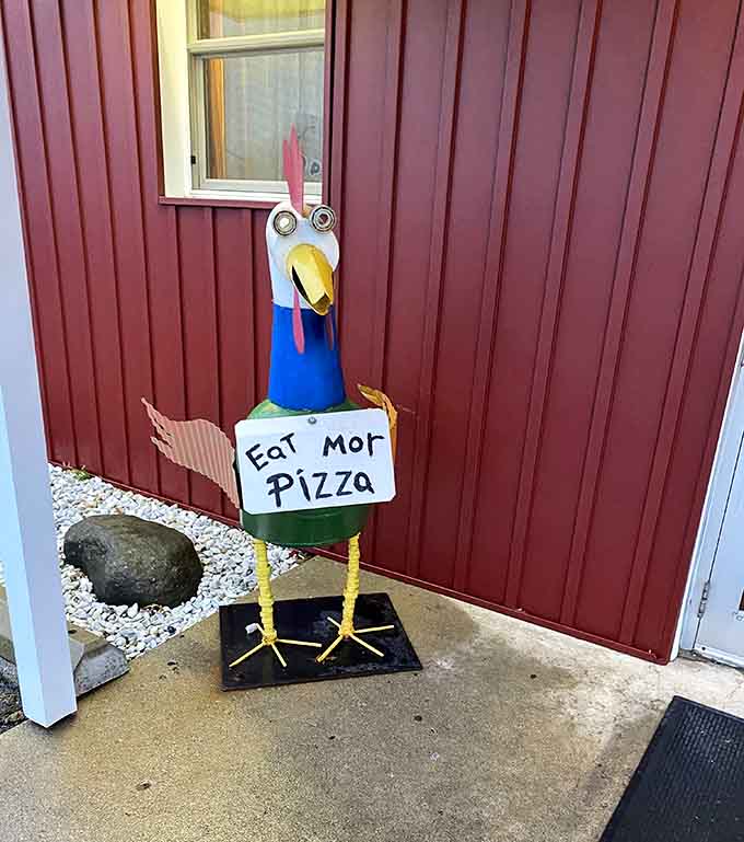 Meet your greeter: a cheerful bird reminding you to "Eat Mor Pizza" with delightful grammatical abandon and infectious enthusiasm.