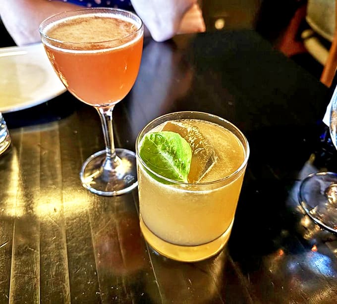 Cocktails crafted with precision &ndash; a cucumber-kissed martini beside a darker, spice-infused concoction, both designed to complement rather than compete with the food.