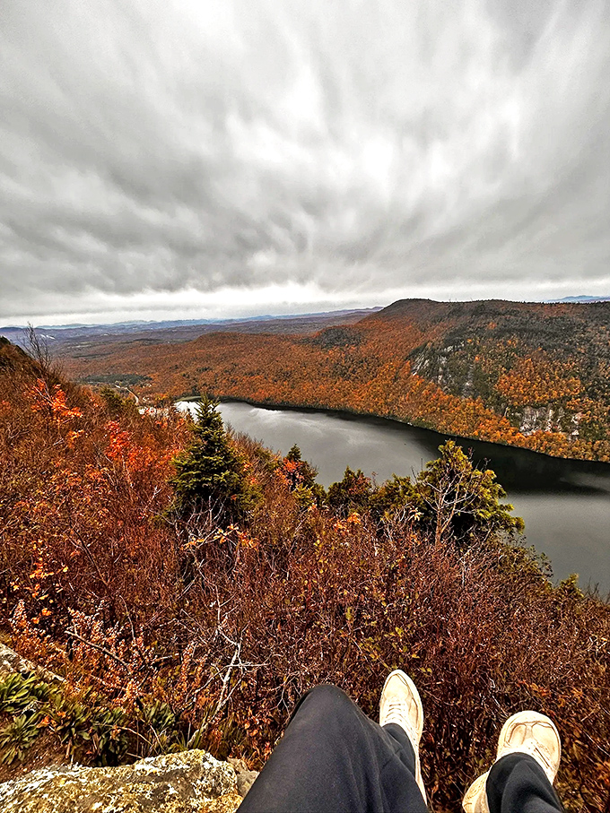 Fall foliage frames Lake Willoughby in fiery splendor, proving that Vermont doesn't just change seasons – it changes dimensions.