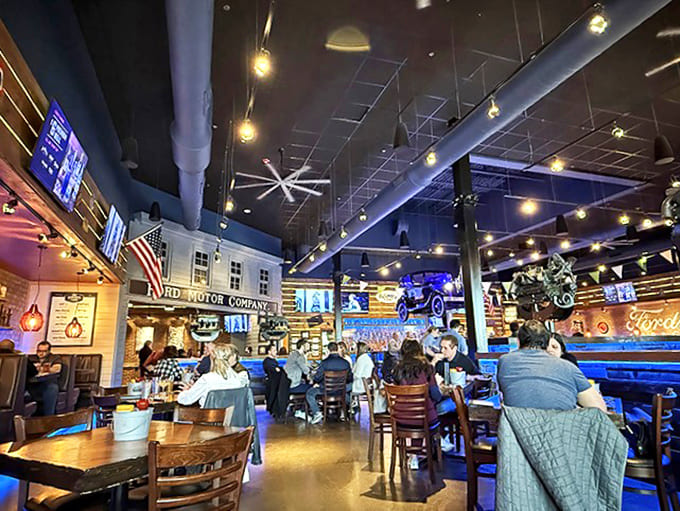 The dining room hums with conversation and laughter, vintage Ford memorabilia watching over patrons like mechanical guardian angels of appetite.