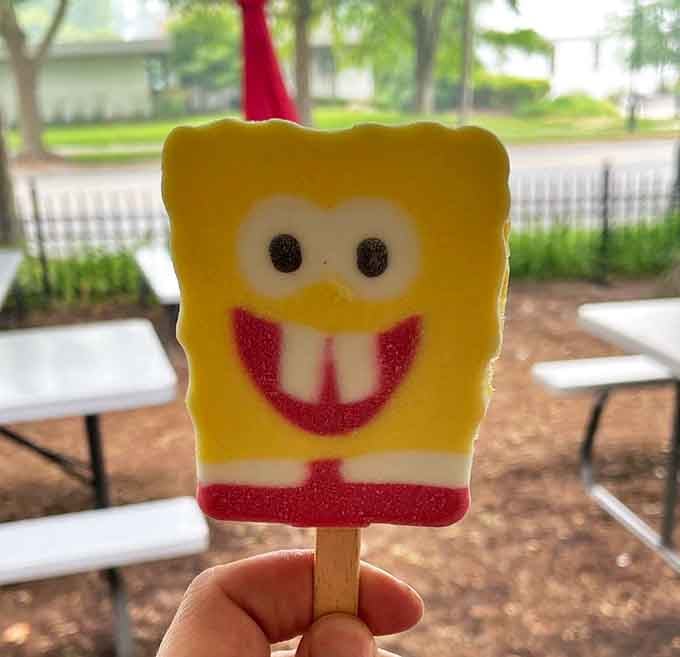 Cartoon character popsicle: A yellow sponge with a wide grin &ndash; childhood nostalgia on a stick that tastes like summer.