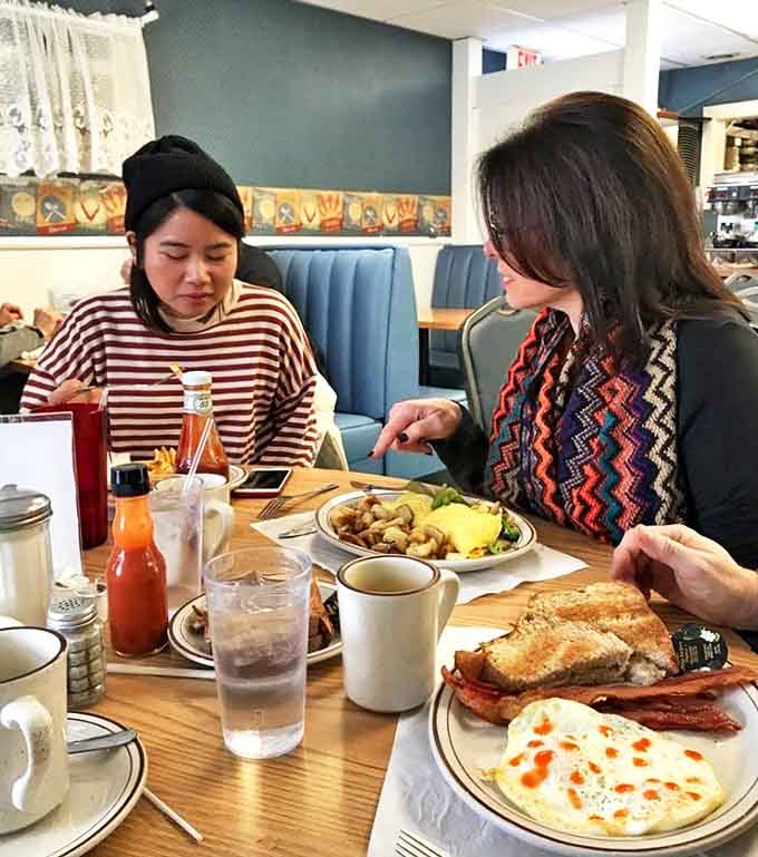 Strangers become friends over shared plates and coffee, creating the warm community atmosphere that defines this place.