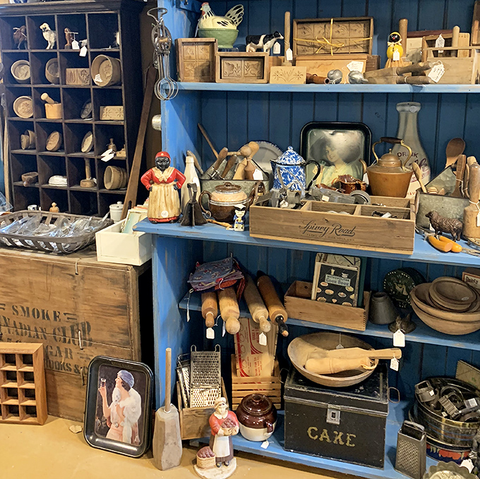 Blue-painted shelves showcase vintage kitchen implements and Americana collectibles that would make any farmhouse kitchen instantly more authentic.