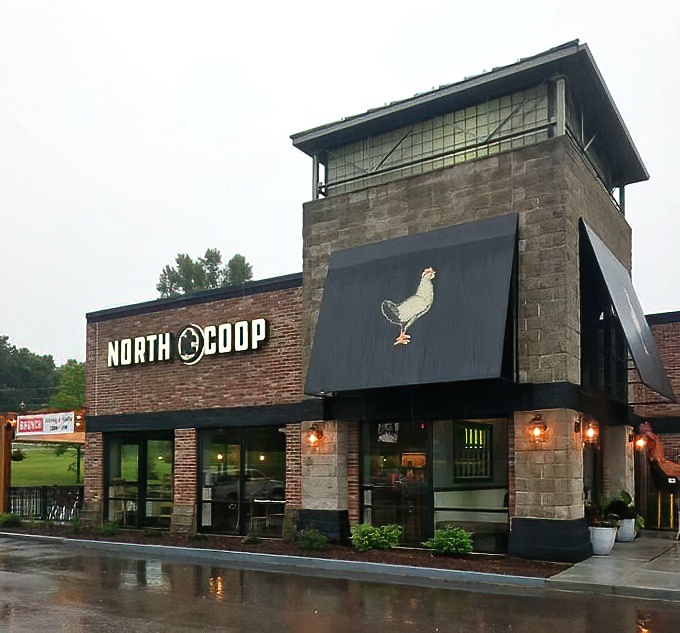 The outdoor patio extends the welcoming atmosphere outside, complete with comfortable seating and that signature rooster keeping watch overhead.