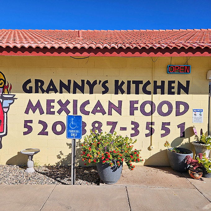 Colorful potted flowers brighten the entrance, a cheerful welcome that hints at the vibrant flavors waiting inside.
