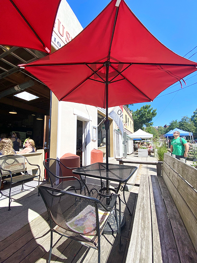 Red umbrellas provide shade for sidewalk diners enjoying their breakfast with a side of Burlington people-watching.