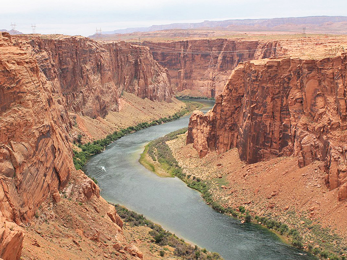 Nature's highway winds through towering canyon walls, telling stories of millennia in every curve.