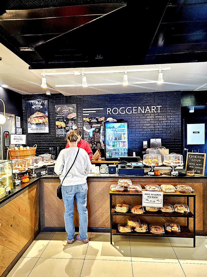 At the counter, freshly baked goods tempt from every angle while friendly staff stand ready to guide your pastry adventure.