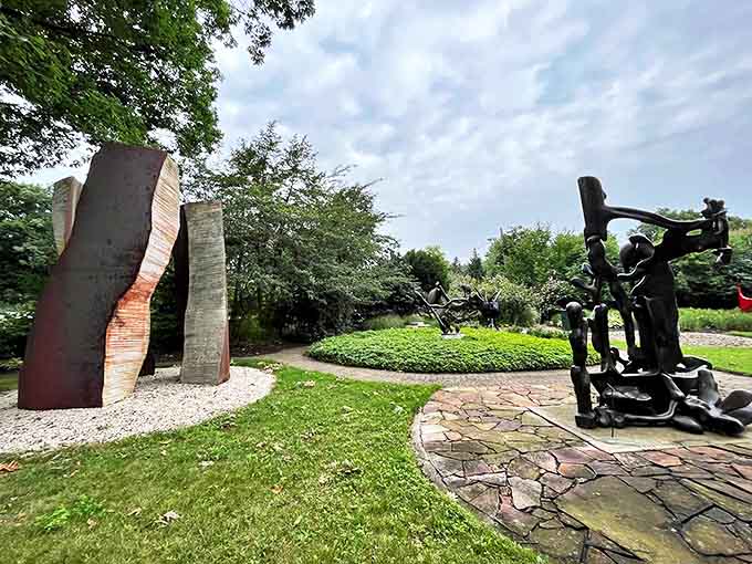 The sculpture garden creates perfect harmony between art and landscape, where metal forms and green growth engage in silent conversation.