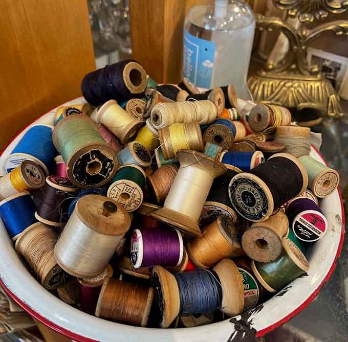Wooden thread spools pile together like colorful memories of sewing projects past, when mending clothes was necessity, not nostalgia.
