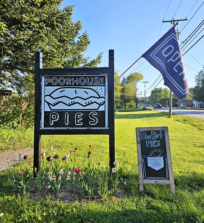 The roadside sign stands like a beacon of hope for pie enthusiasts. Those tulips aren't just pretty&mdash;they're celebrating the pie paradise beyond.