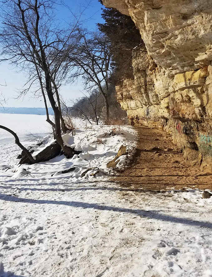 Winter transforms the riverside trail into a snow-dusted wonderland, where limestone bluffs shelter hikers from winter winds.