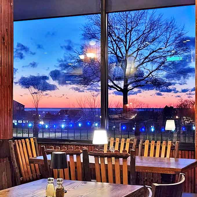 As day turns to dusk, Schu's windows frame a spectacular Michigan sunset, creating the perfect backdrop for memorable meals and conversations.