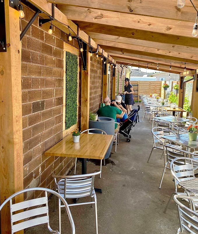The covered patio extends your dining options into the fresh air, complete with string lights for that magical evening ambiance that makes everything taste slightly better somehow.