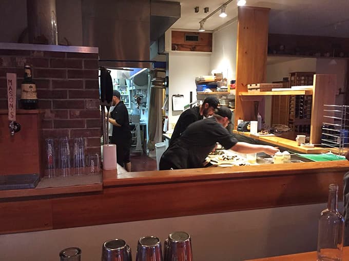 The prep area buzzes with activity as skilled hands craft each pizza with the care it deserves.