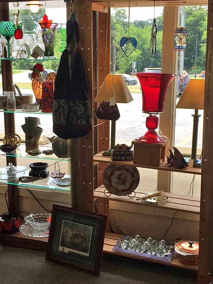 Stained glass catches the afternoon light, casting colorful shadows across vintage treasures in this carefully curated window display.