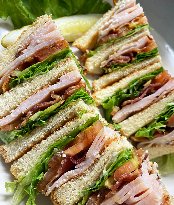 This isn't just a sandwich&mdash;it's architectural genius with layers of turkey, bacon, and fresh vegetables defying the laws of sandwich physics.