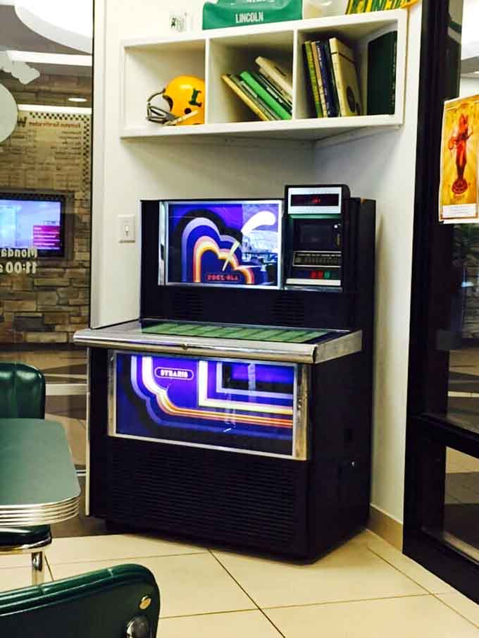 A vintage Rock-Ola jukebox stands ready to provide the soundtrack to your sandwich experience, if it still works.