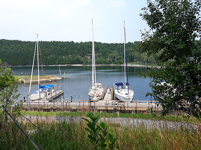 Sailboats bob gently in the harbor where massive cargo vessels once loaded Fayette's iron, the peaceful present contrasting with the industrial past.