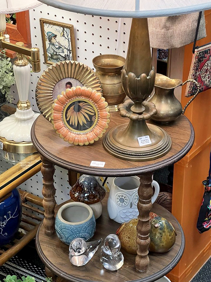 This tiered display showcases brass and ceramic treasures, from ornate picture frames to decorative vessels with timeless appeal.