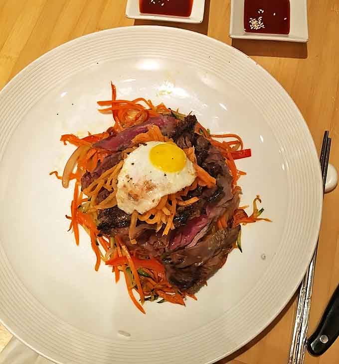 This isn't just a bowl &ndash; it's a colorful celebration topped with a sunny-side egg that's waiting to release its golden treasure.