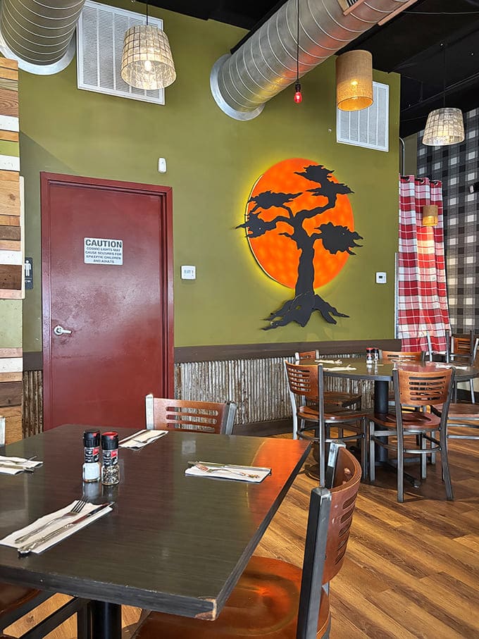 The illuminated bonsai tree mural casts a warm glow across the dining room, creating an atmosphere where food becomes more than just sustenance.