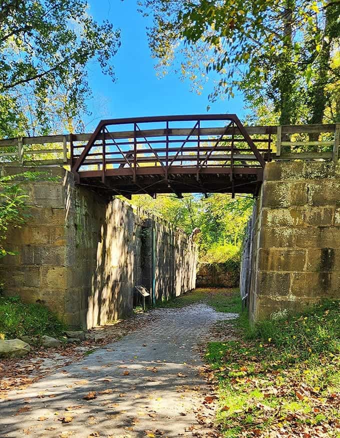 Historic Canal Lock: Massive stone walls frame the path where canal boats once traveled, now repurposed for hikers and cyclists.