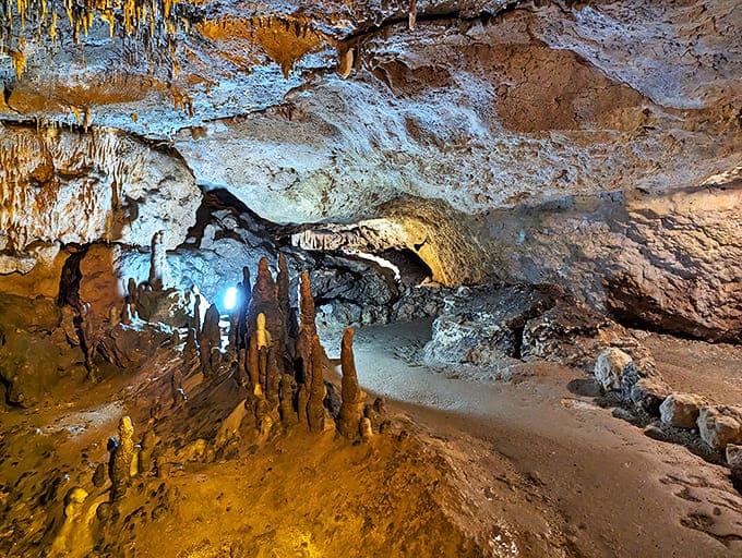 Shadows and light play across ancient formations, creating a cathedral-like atmosphere where visitors instinctively lower their voices in reverence.