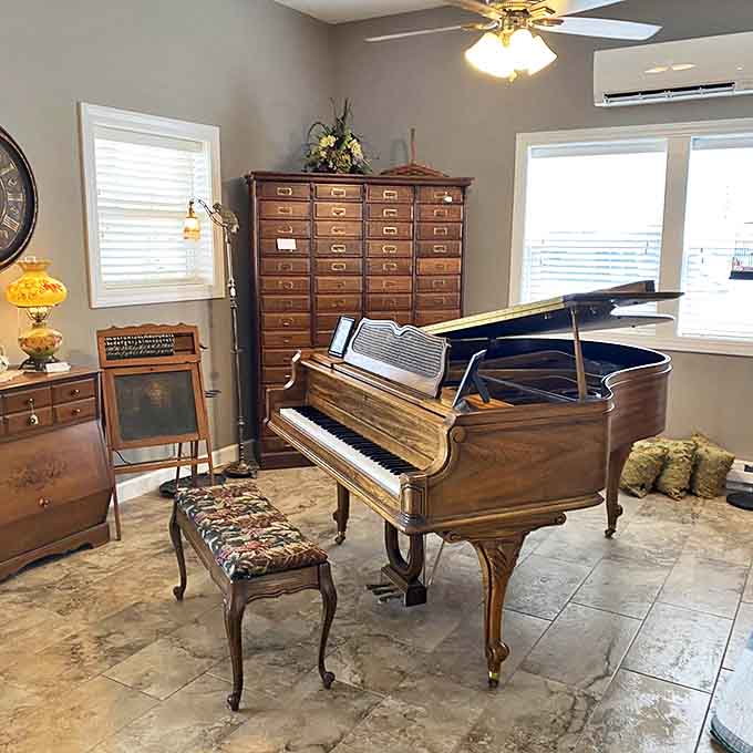 A grand piano sits waiting, its polished wood and ivory keys ready to fill the space with music once again.
