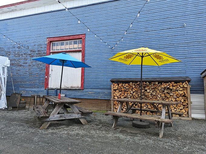 Simple picnic tables, stacked firewood, and bright umbrellas &ndash; sometimes the best dining rooms have no walls at all.