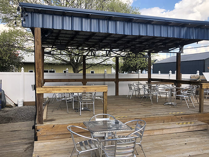 Simple metal tables and chairs create a no-fuss outdoor dining space where the food remains the undisputed center of attention.