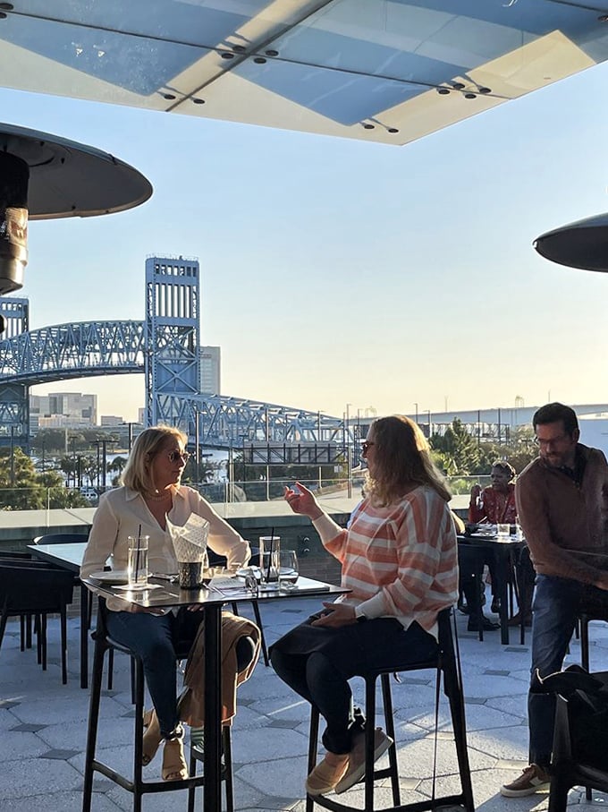 Rooftop revelry with a view &ndash; patrons enjoy cocktails and conversation while Jacksonville's iconic bridge creates the perfect backdrop.