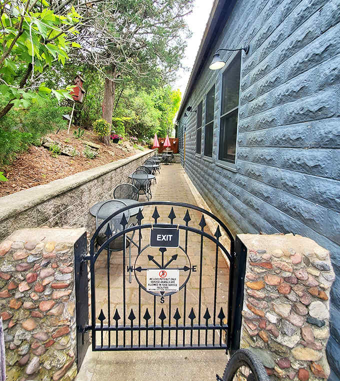 The charming outdoor seating area offers a peaceful retreat for fair-weather dining &ndash; complete with wrought-iron gate and lush greenery.