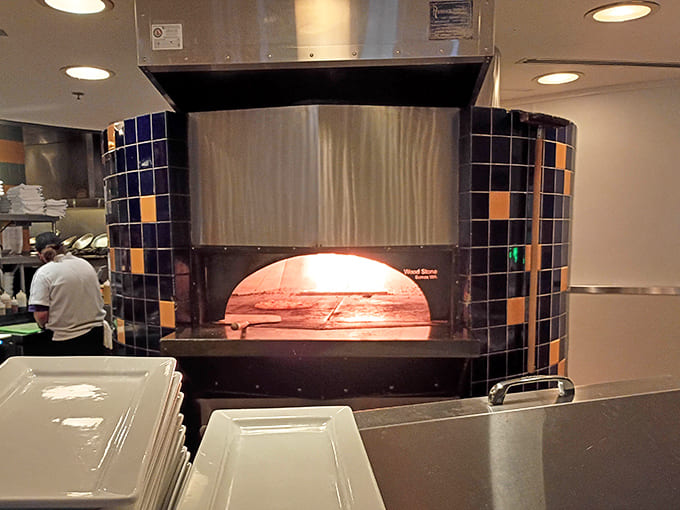 The pizza oven &ndash; tiled in vibrant blues and oranges &ndash; isn't just functional, it's theater. Where dough transforms into charred, bubbly perfection.