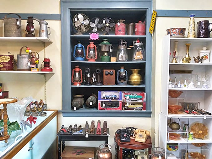 A rainbow of vintage lanterns and antique telephones line these blue shelves, technological relics that once illuminated homes and connected loved ones.