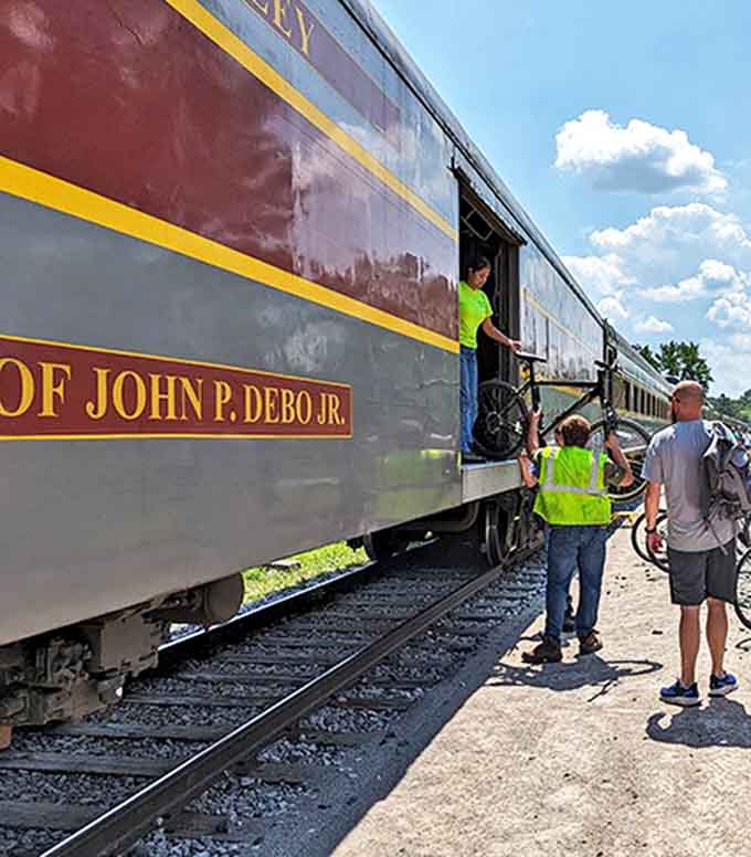 Excited passengers prepare to board with bicycles in tow, ready for the popular "Bike Aboard" program that combines rail and trail adventures.