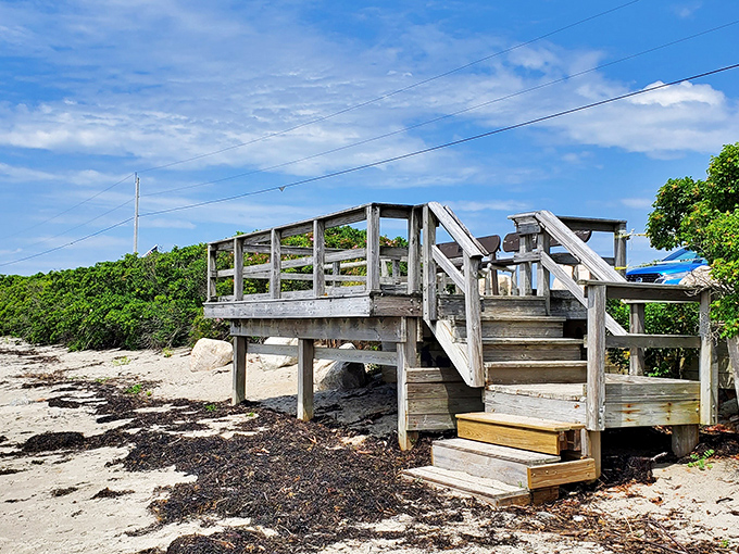 This weathered staircase has witnessed countless excited footsteps rushing toward beach adventures and quiet retreats from modern life.