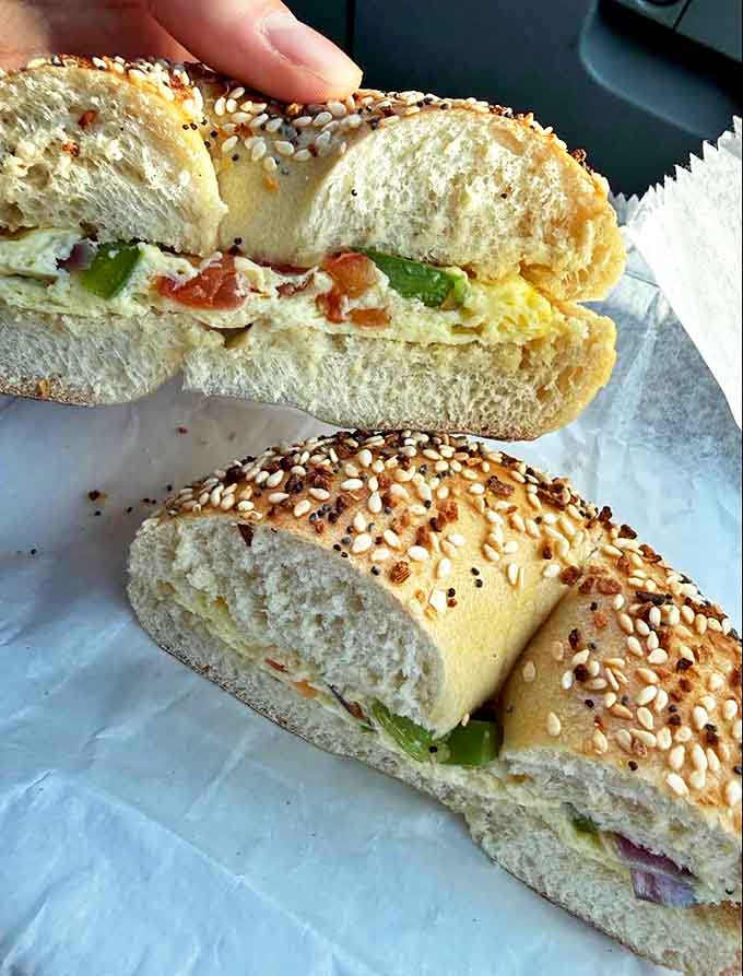 This everything bagel sandwich, split to reveal its perfect filling-to-bread ratio, demonstrates why some food doesn't need filters to look irresistible.