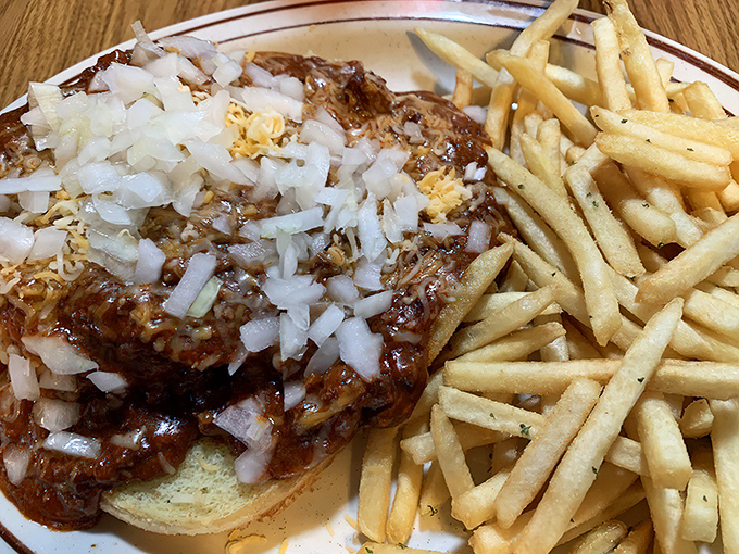 A chili cheeseburger topped with diced onions &ndash; messy, magnificent, and worth every napkin you'll need to clean up afterward.