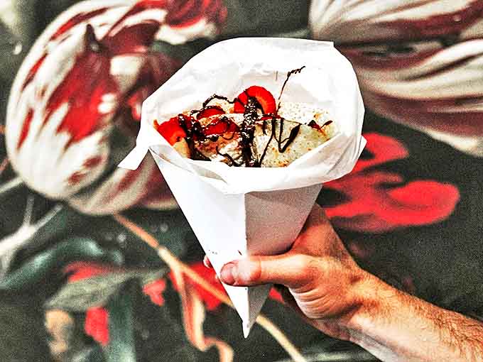 Chocolate drizzle and fresh strawberries in a handheld crepe cone prove that portable desserts can be just as elegant as plated ones.