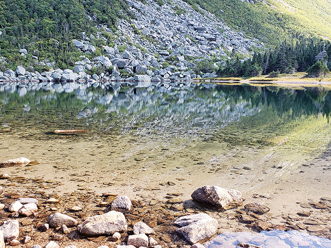 Nature's infinity pool: Chimney Pond's crystal waters reflect every detail of the surrounding landscape in perfect, undisturbed clarity.
