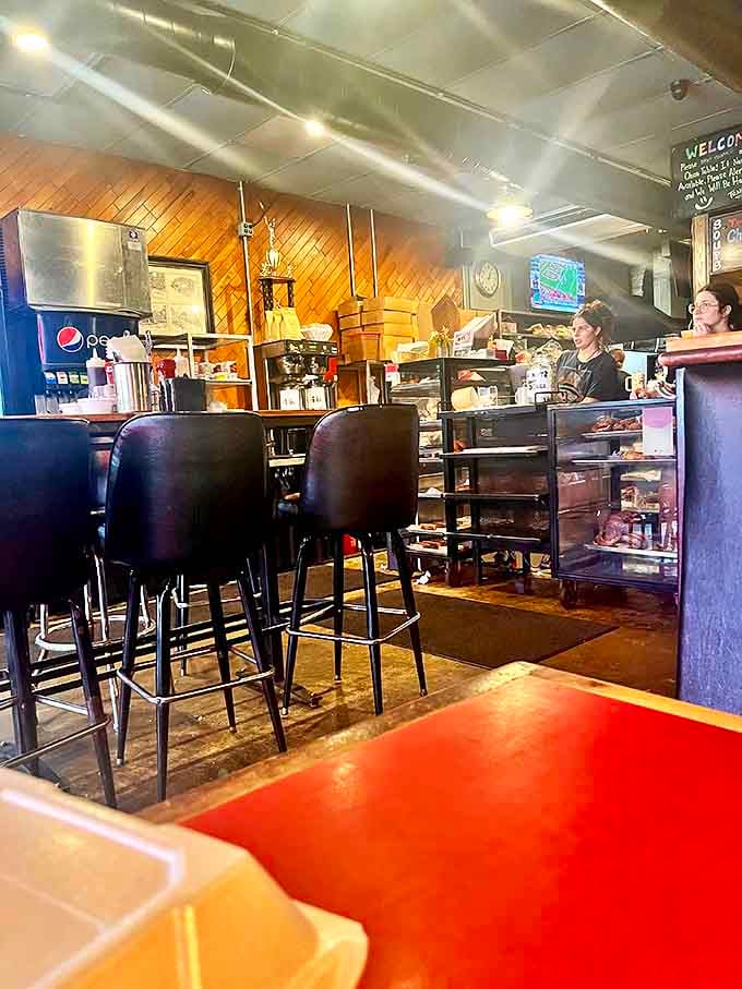 Behind the counter where breakfast magic happens daily. Those stools have supported countless happy customers on their donut burger journeys.