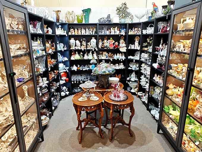 Dolls and glassware sharing shelf space in perfect harmony, proving that collections don't need to make sense to make you happy and nostalgic.