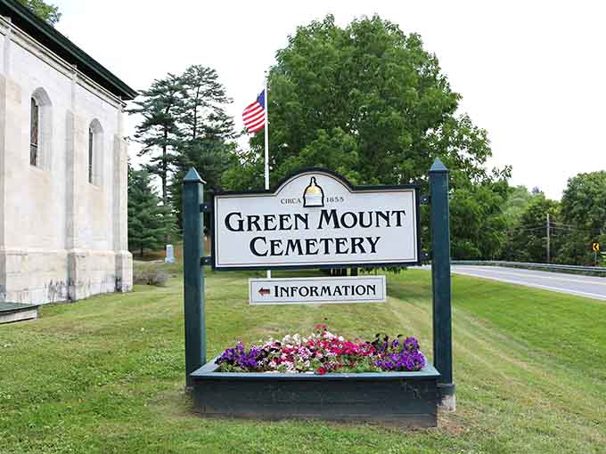 The Green Mount Cemetery sign welcomes visitors with flowers and dignity, proving that even places dedicated to endings can celebrate beauty and life.